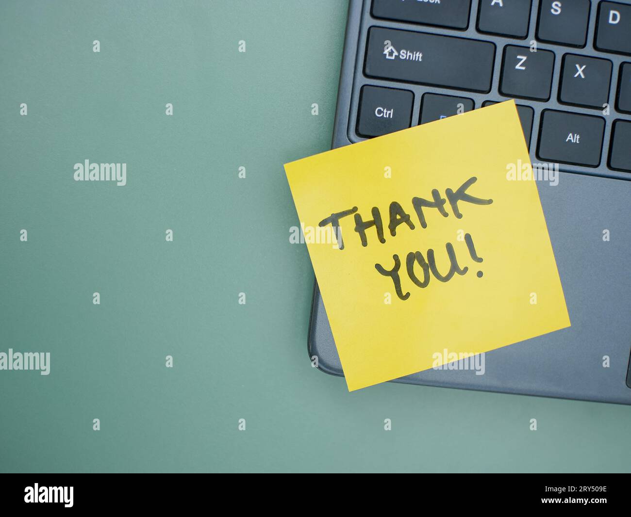 Top view of words thank you written on sticky note on laptop keyboard ...