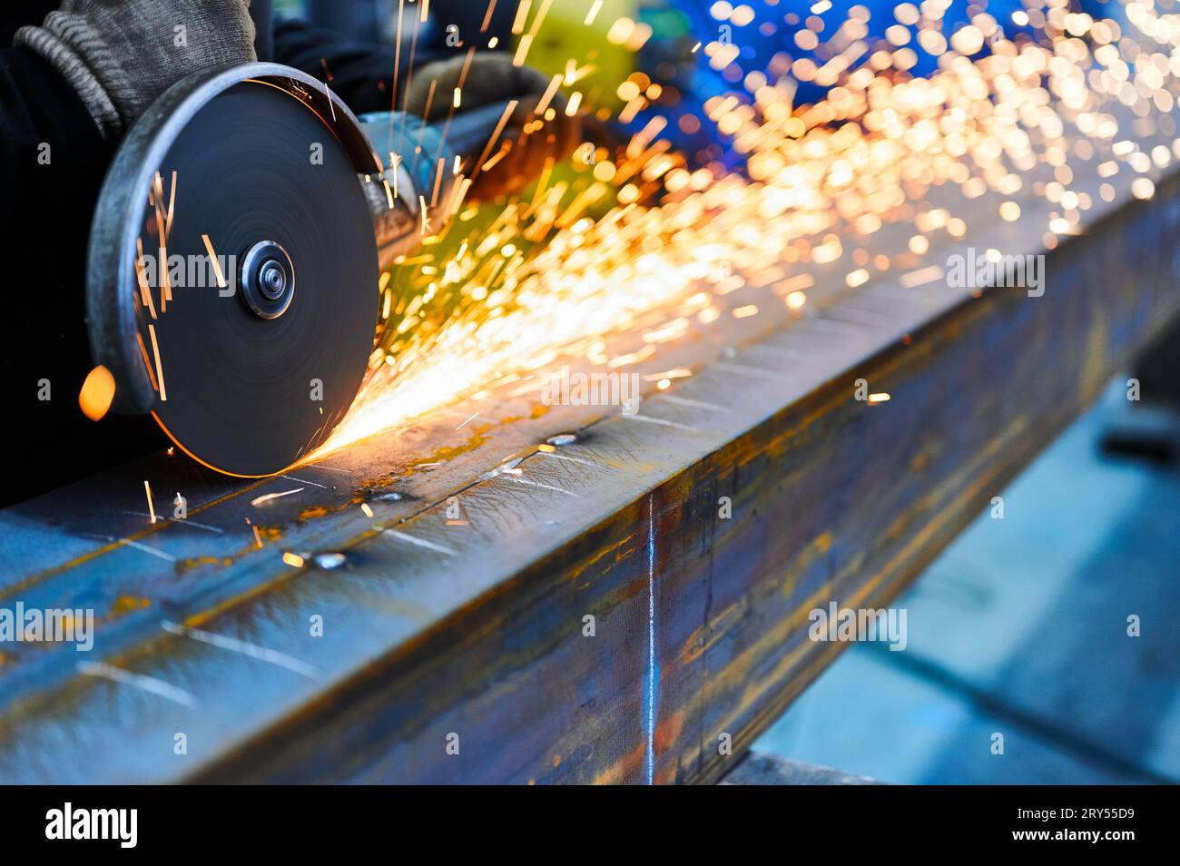 Worker cuts metal beam with abrasive disk in plant workshop Stock Photo ...