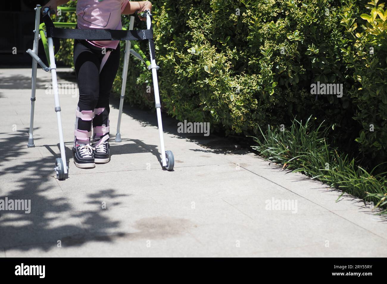 child with walking frame and knee orthosis outdoor Stock Photo - Alamy