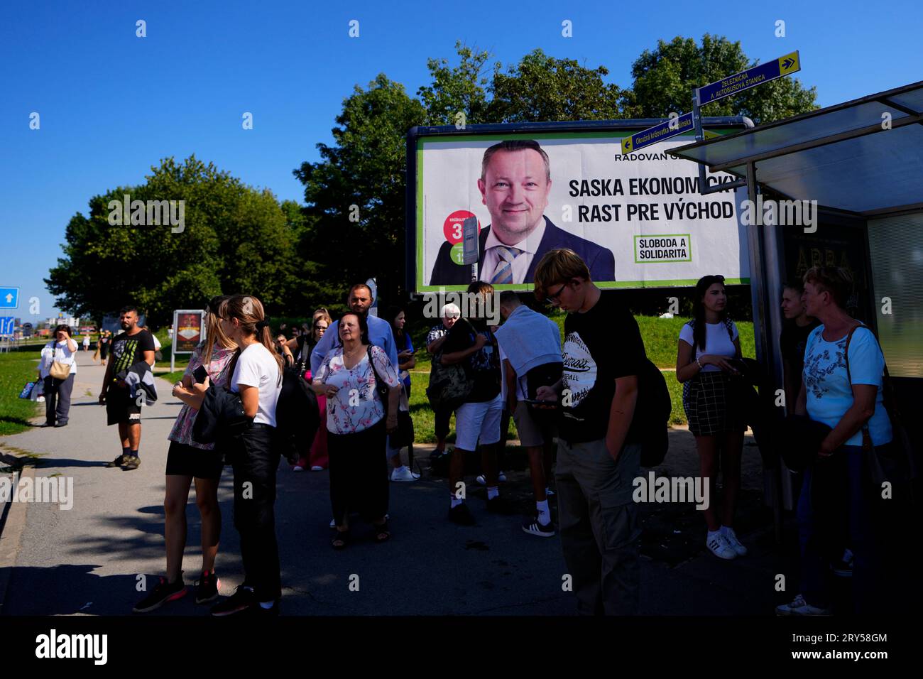 People wait for a bus by an election billboard for "SaS" (Freedom and ...