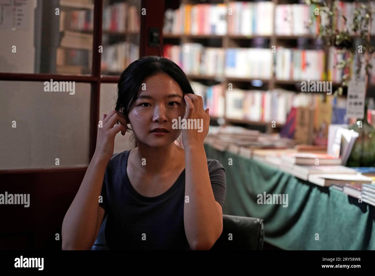 Chai Yujia tidies her hair as she poses for photos at a bookstore that ...