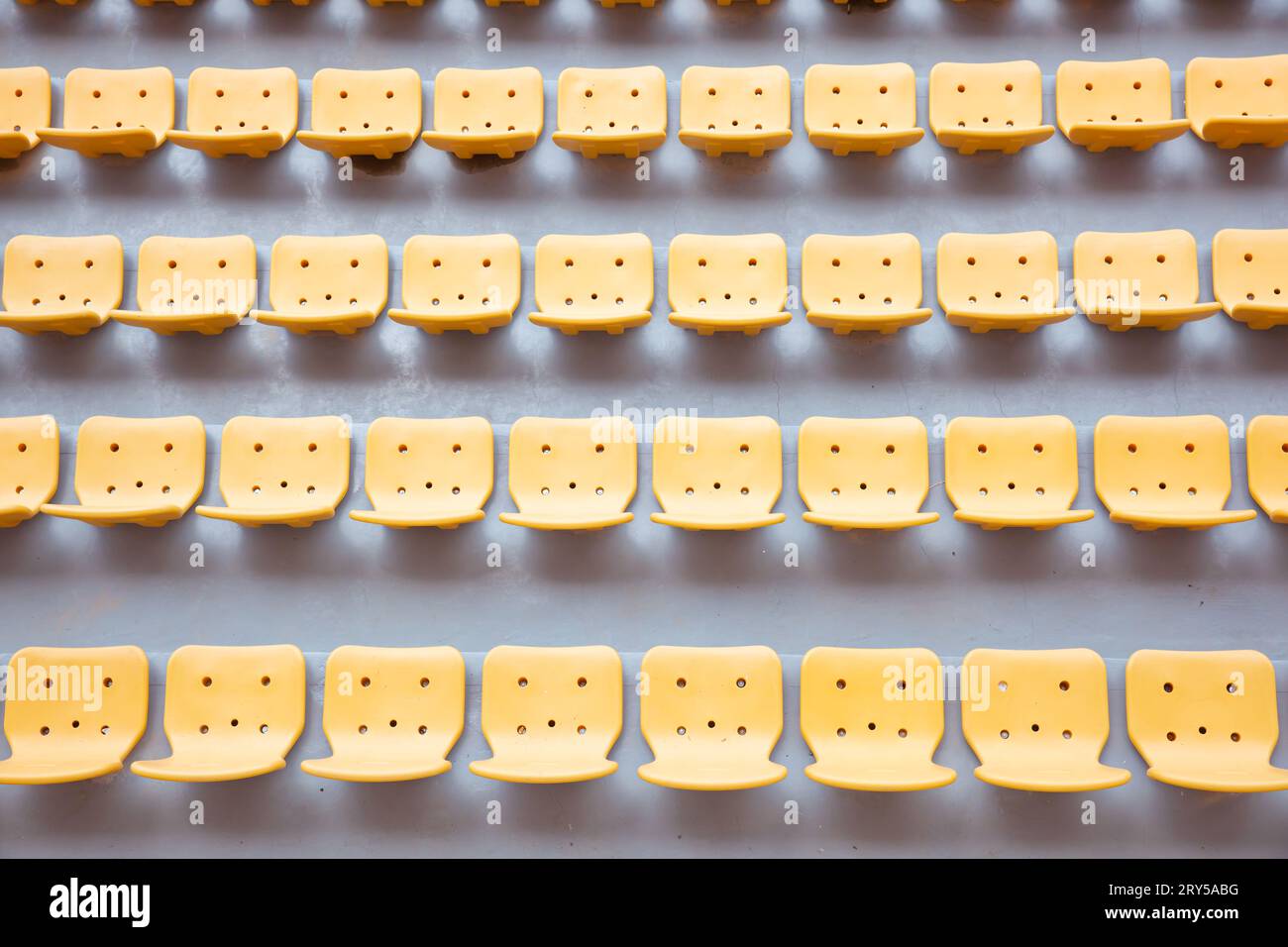 Top view of yellow seats on sport stadium with the chairs are lined up ...