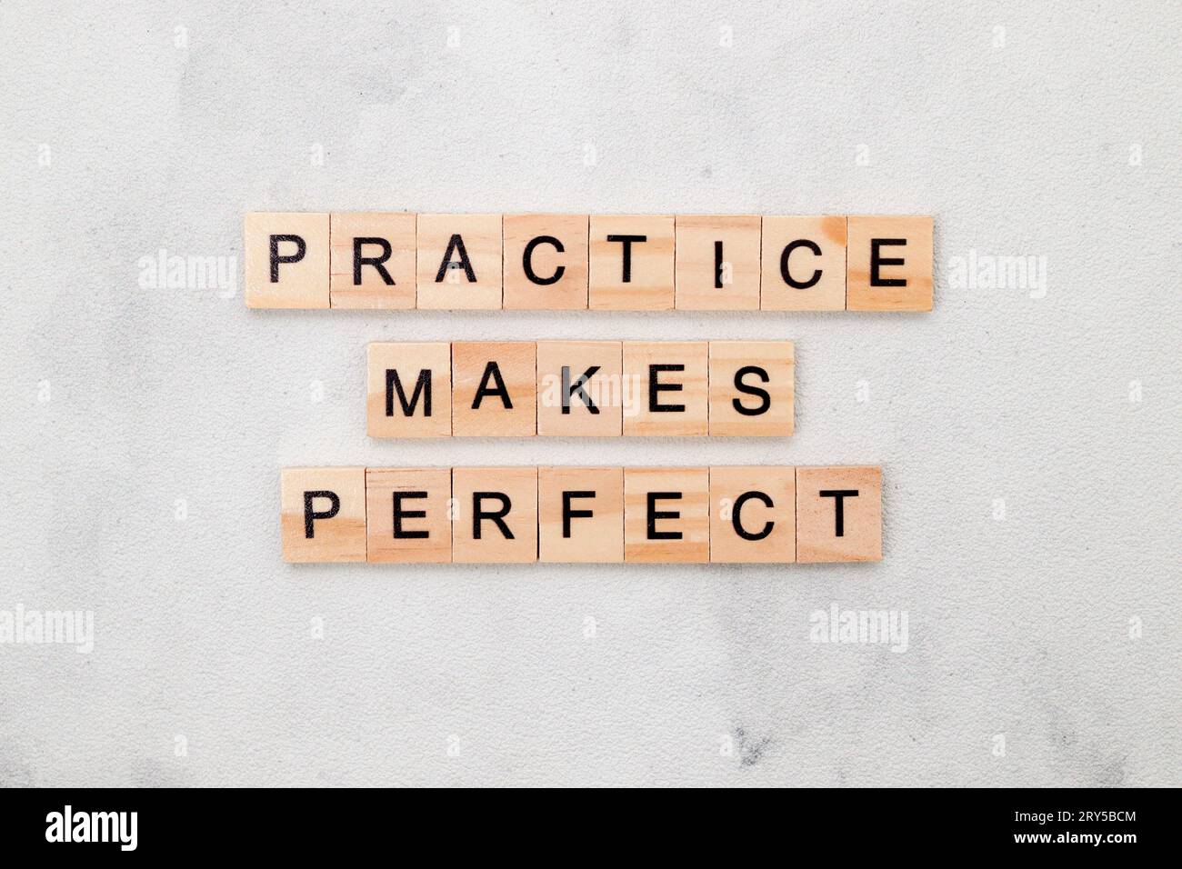 Top view of Practice Makes Perfect words on wooden cube letter block on ...