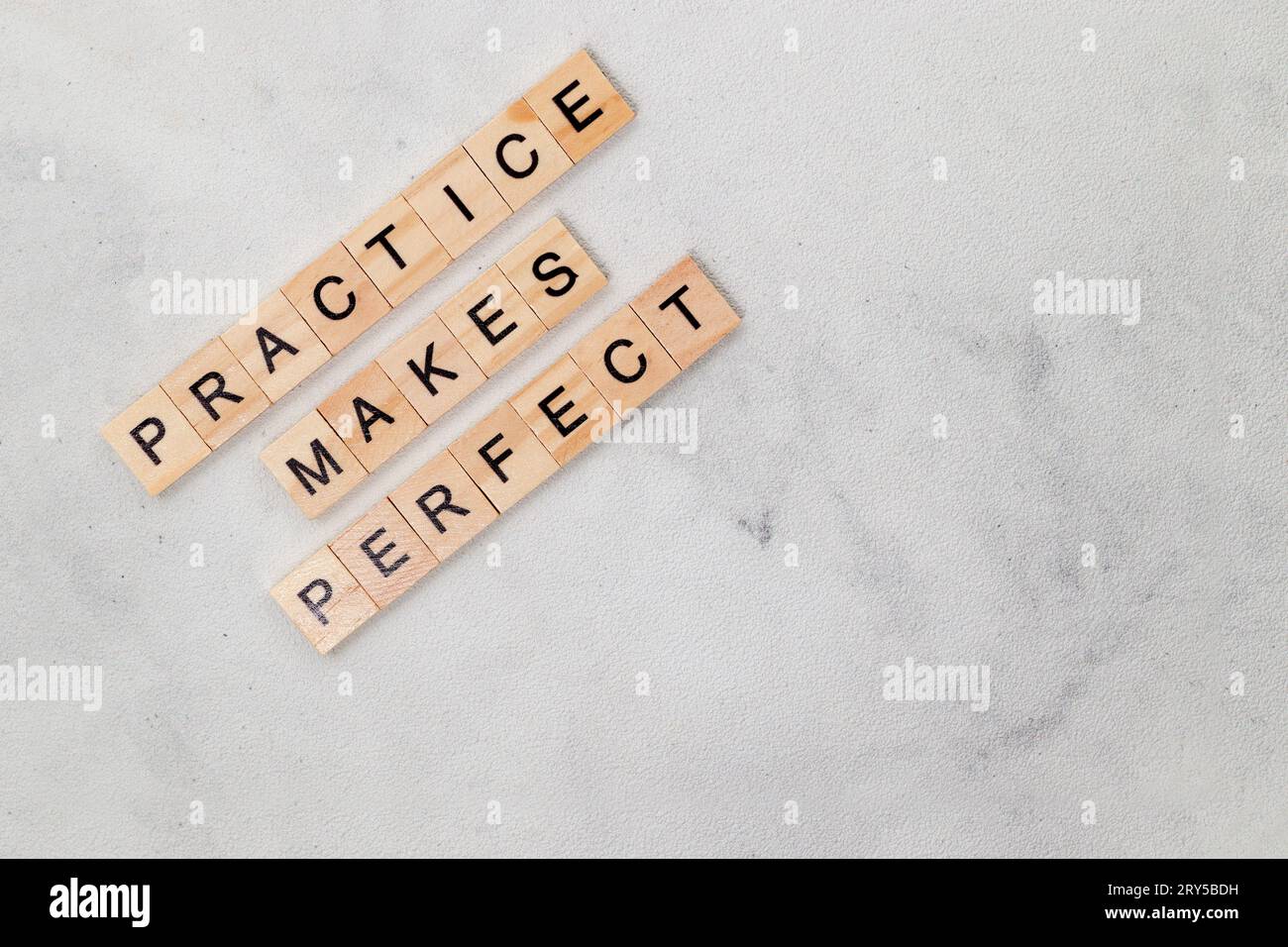 Top view of Practice Makes Perfect words on wooden cube letter block on ...