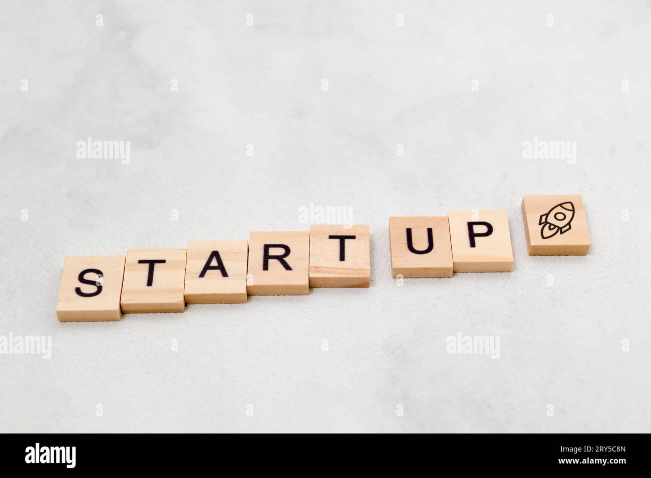 Top view of Start Up word on wooden cube letter block on white ...