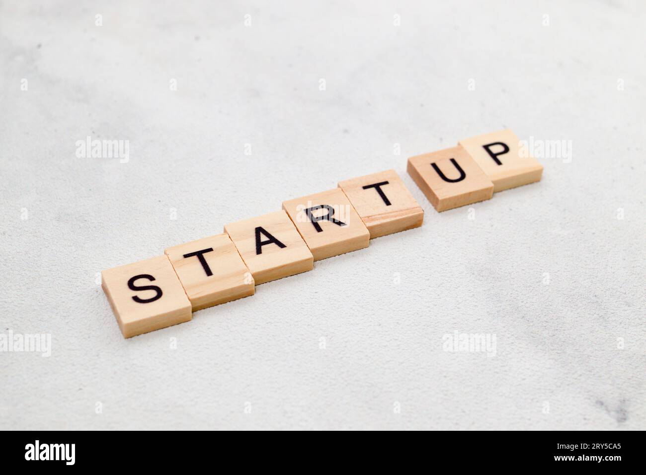 Top view of Start Up word on wooden cube letter block on white ...