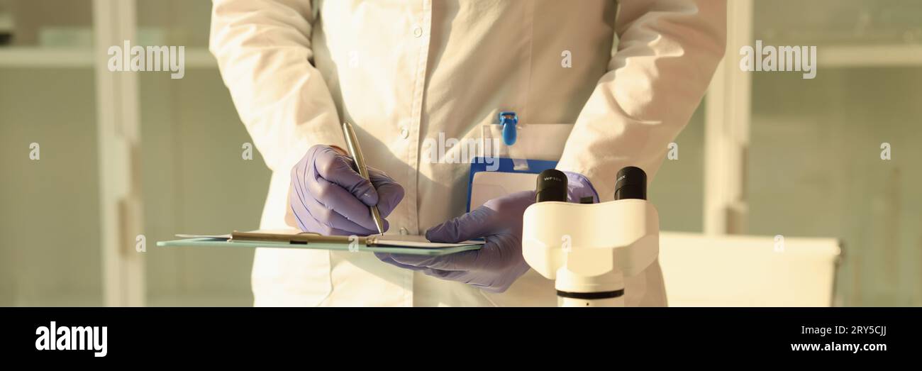 Woman in uniform makes notes after doing urine sample test Stock Photo ...