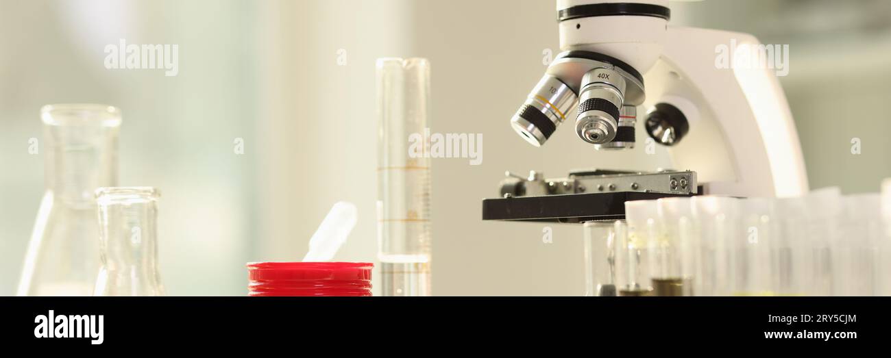 Flasks and tubes with colored liquids stand near microscope Stock Photo ...