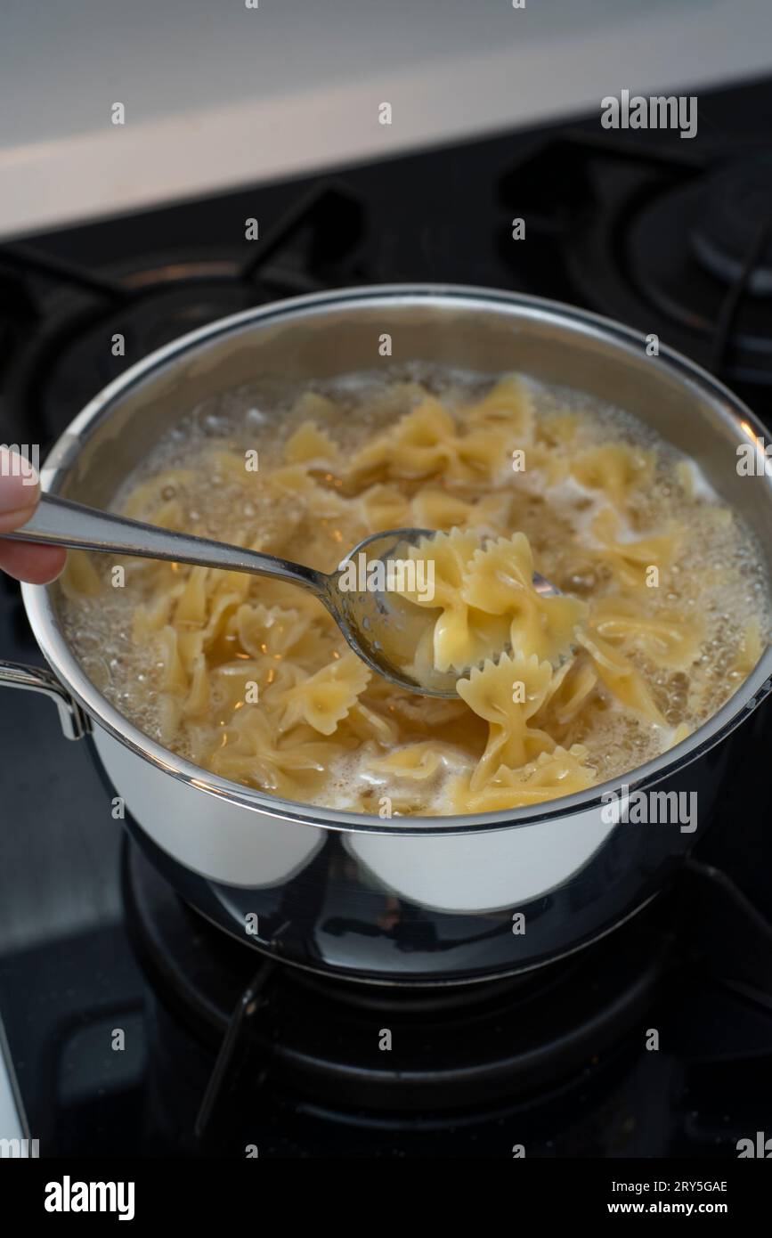 Pasta boiling in a pot.Stir with a spoon and check the readiness of the ...