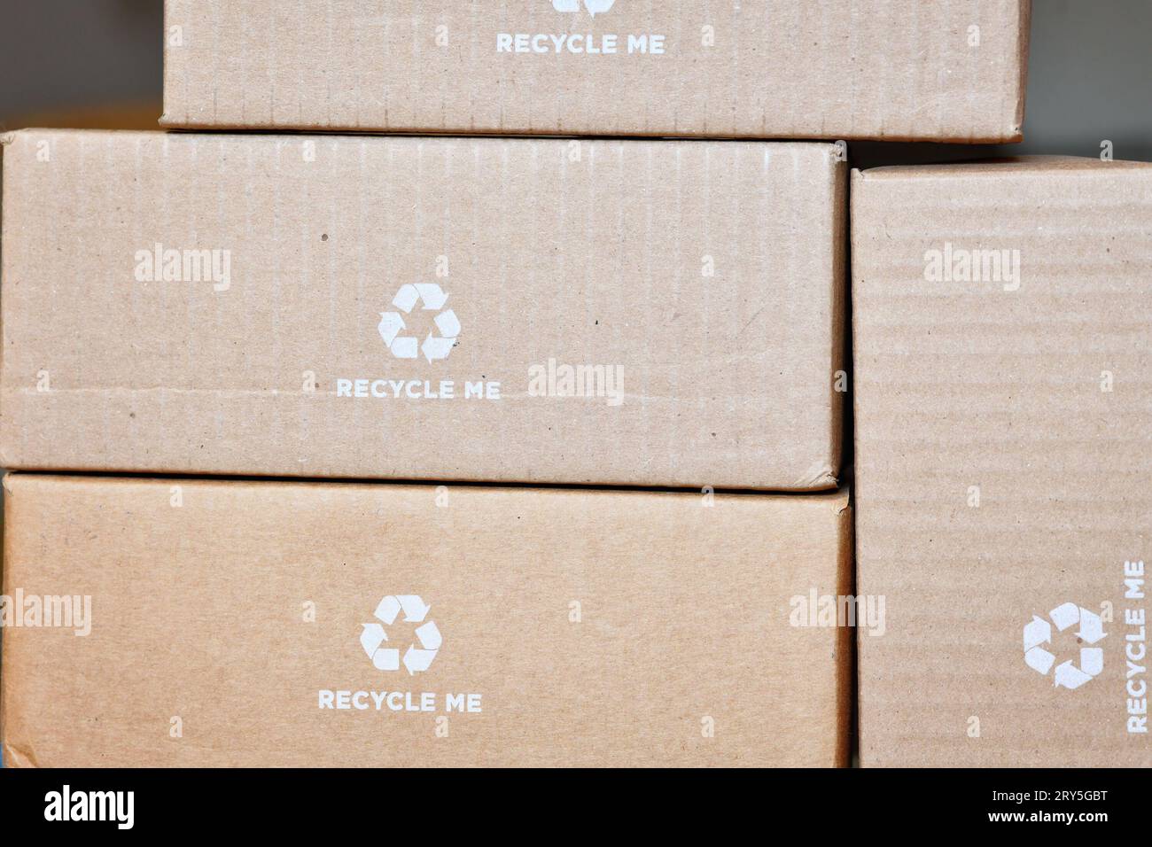 Many cardboard boxes with recycling arrow symbol and text saying ...