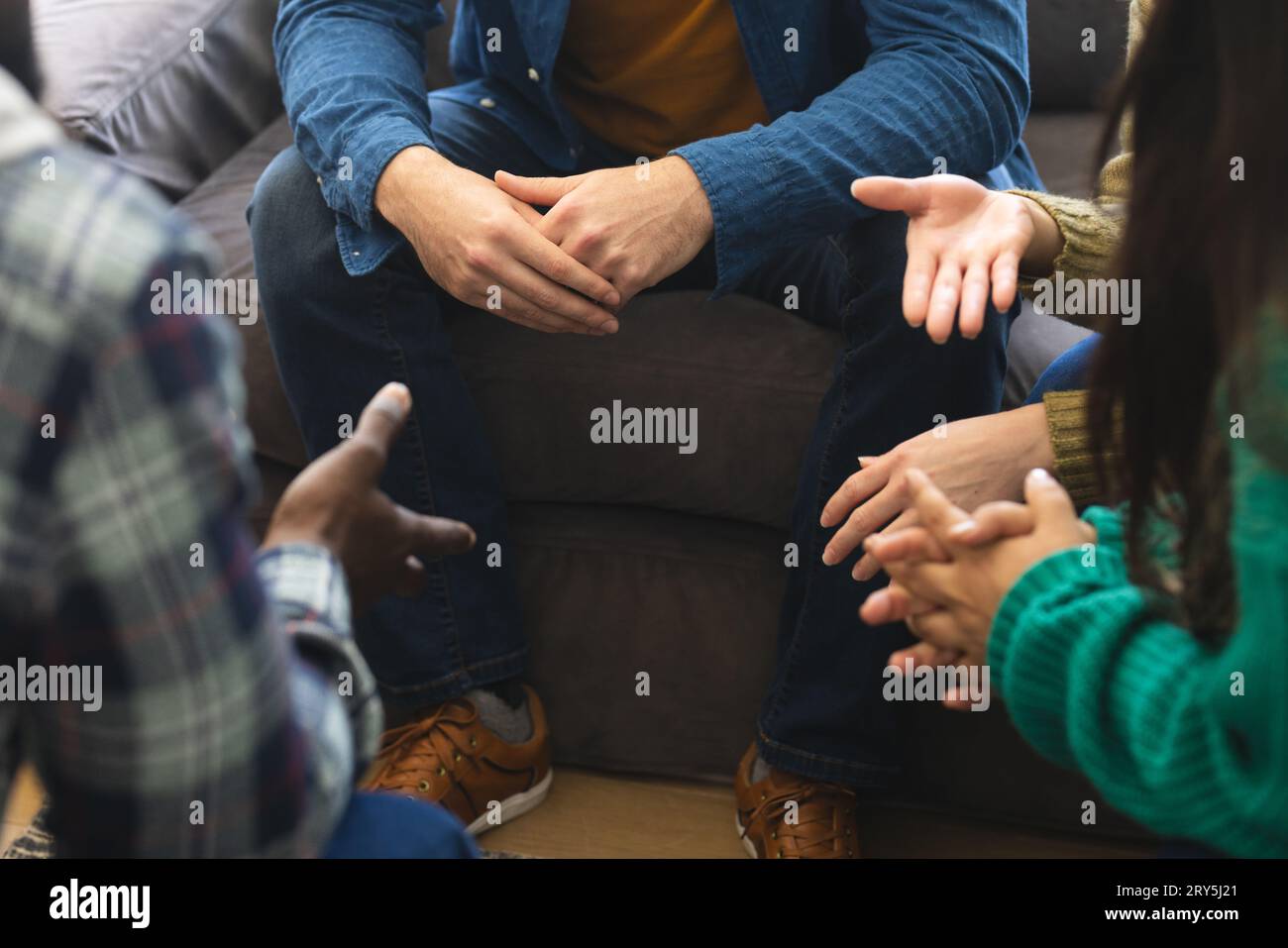 Hands of diverse group of friends talking and supporting each other on ...