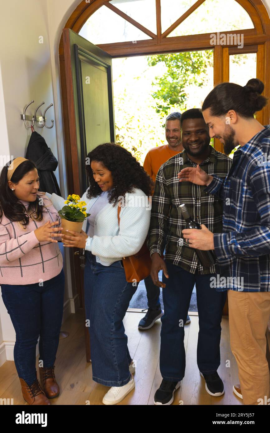 Happy diverse couple receiving guests in sunny house Stock Photo - Alamy
