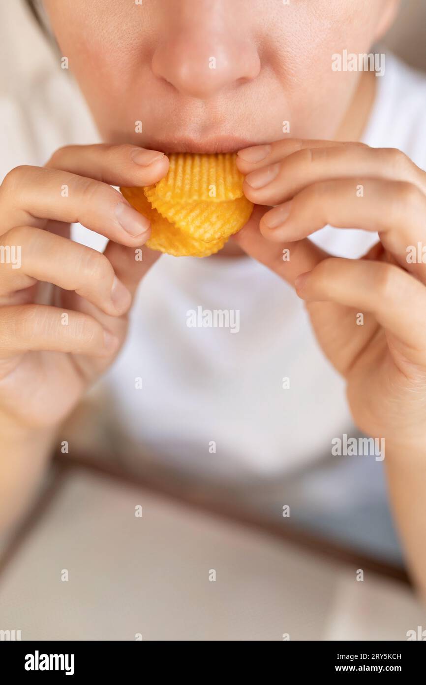 woman eating potato chips for snack Stock Photo - Alamy