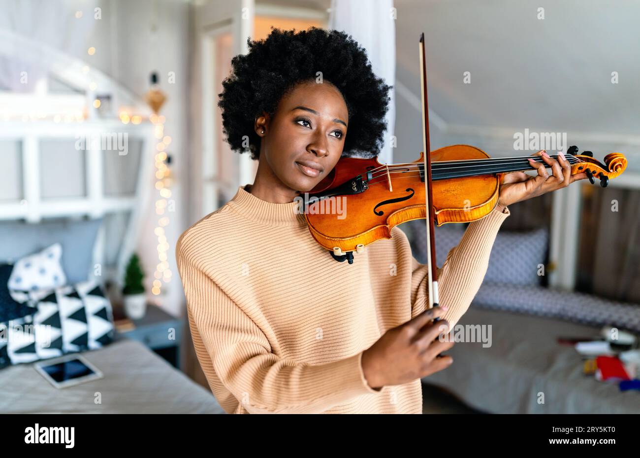 Attractive young african american woman musician plays the violin ...