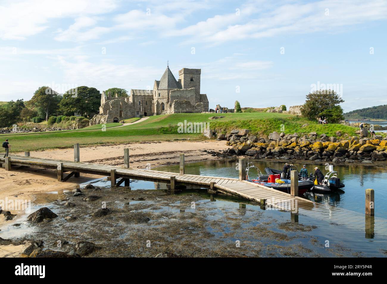 A wooden pier on Inchcolm Island with Inchcolm Abbey in the background ...