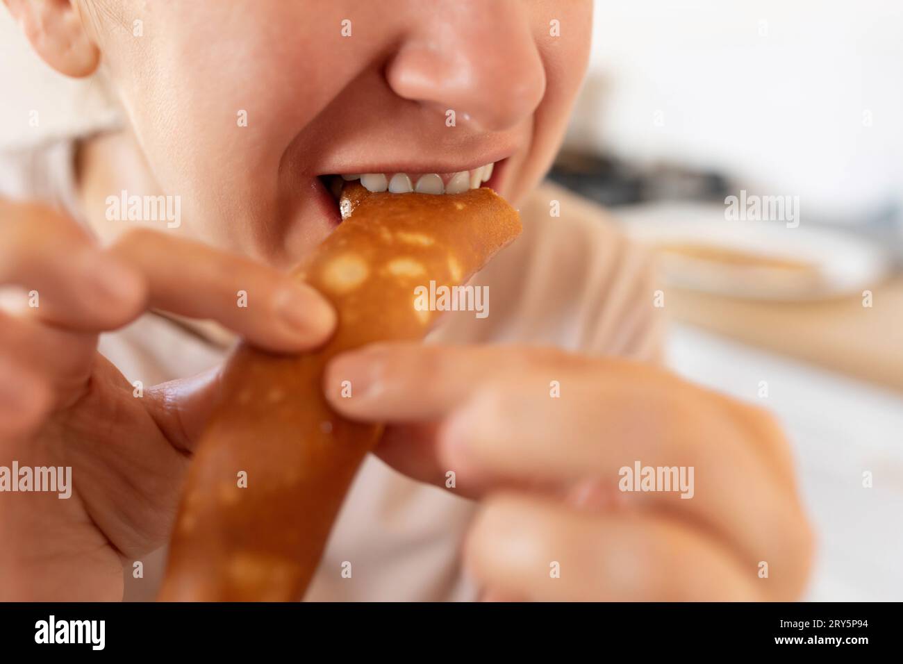a woman has breakfast with pancakes in her kitchen. close-up of putting ...