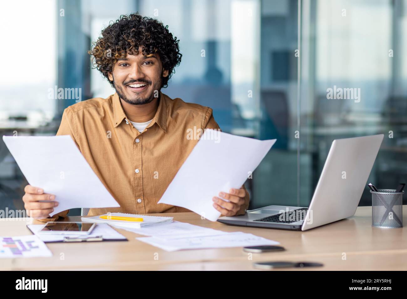Portrait of young successful financier businessman paper work, hispanic ...