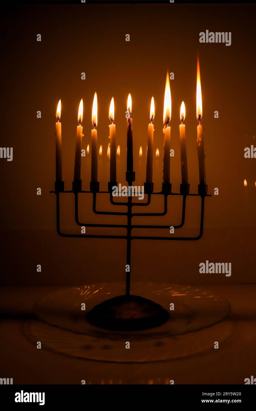 A full menorah on the last night of Hanukkah. Eight white candles and ...