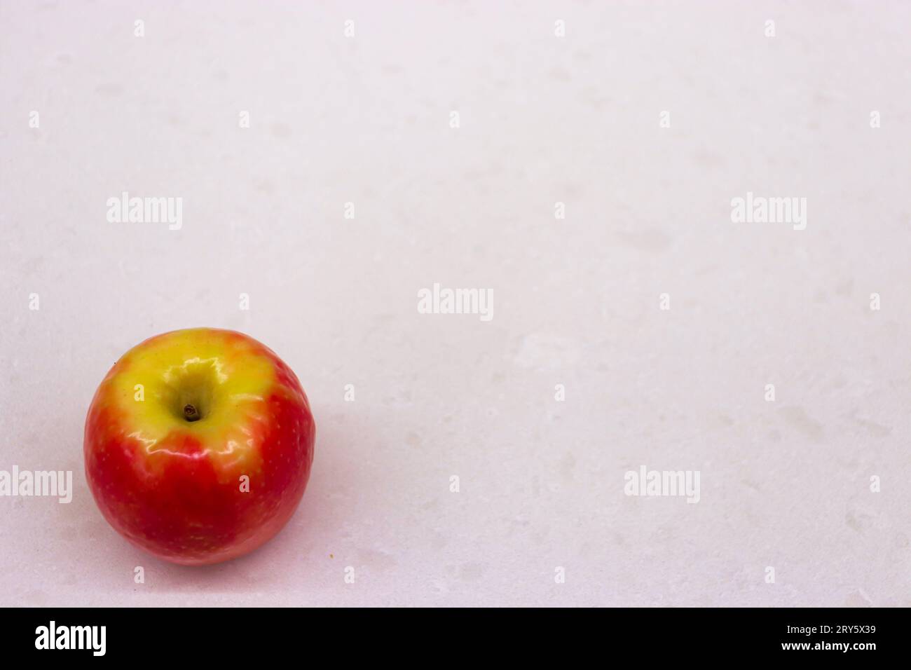 Cripps Pink, red apple closeup sitting on a white countertop. Rosh ...