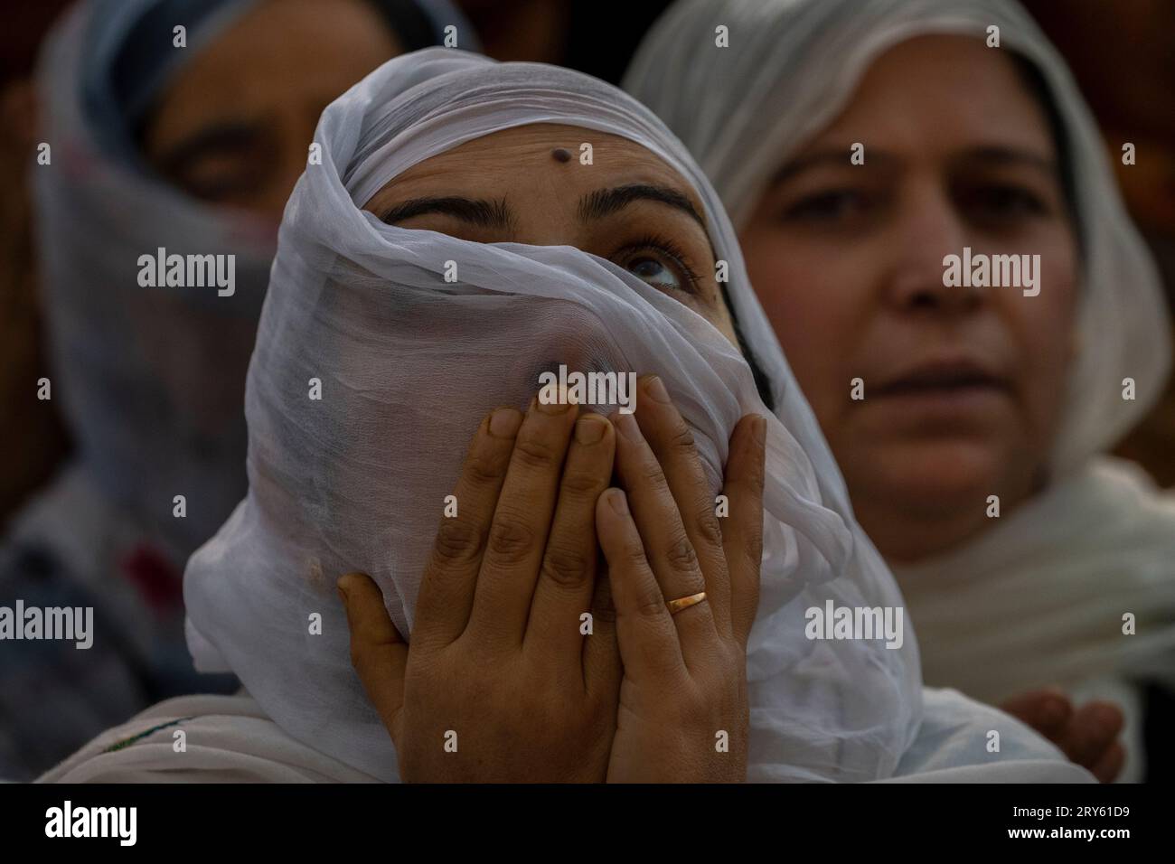 A Kashmiri Muslim prays as a head priest displays a relic, believed to ...