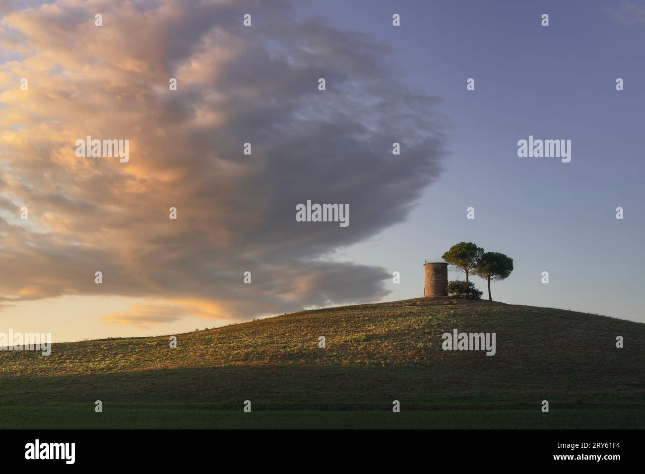 Tuscany, Maremma countryside landscape. Old windmill and trees on top ...