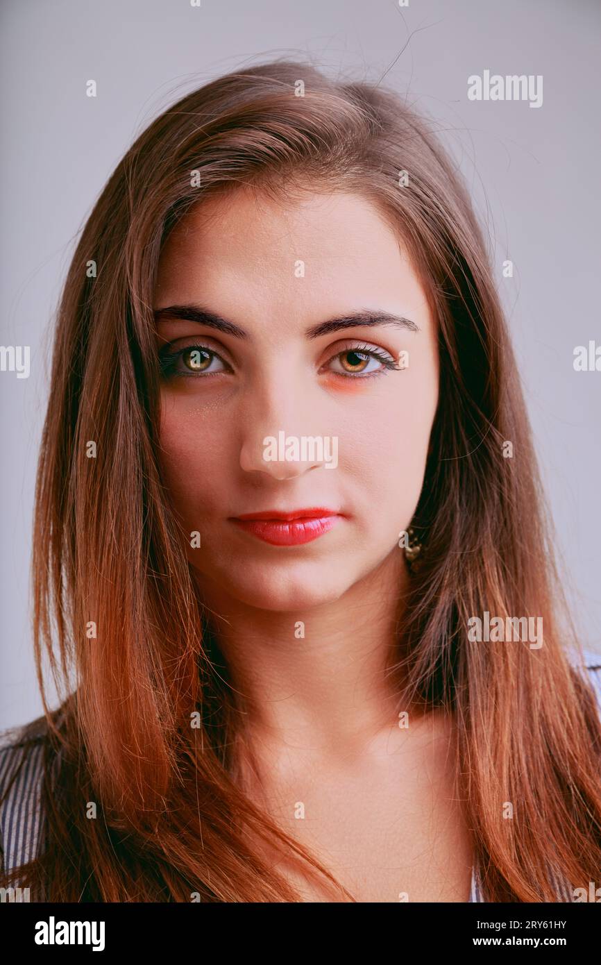 Woman with serious expression, long reddish-brown hair, red lipstick ...