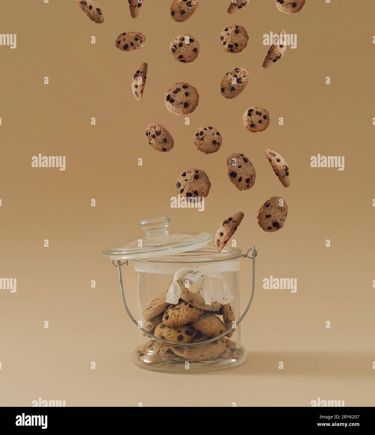 Chocolate chip cookies coming out of jar against cream pastel ...