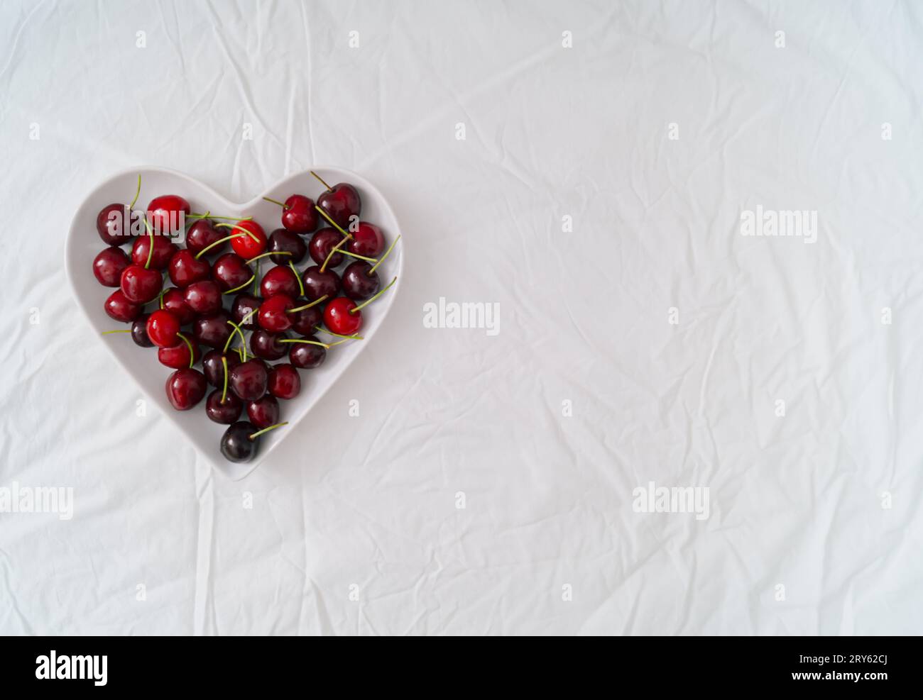 Creative love layout in shape of a heart made of red cherries. Minimal ...