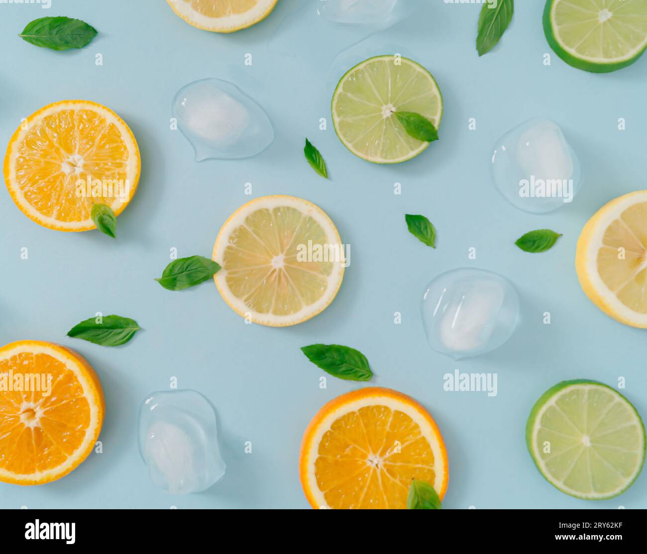 Creative summer background composition with orange, lemon and lime slices, green mint leaves and ...