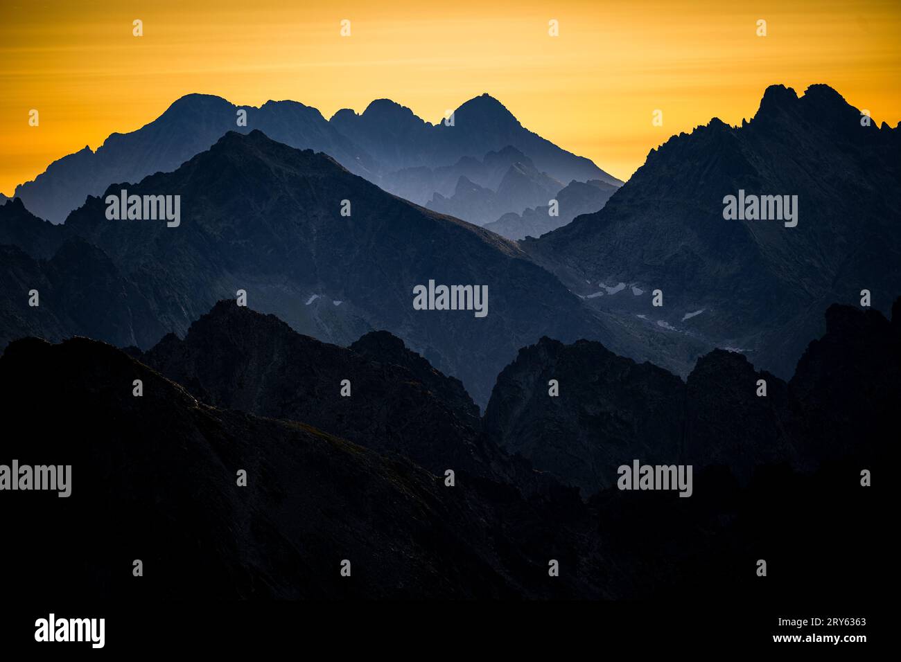 Dark silhouettes of the High tatras from the Mount Krivan at sunrise ...