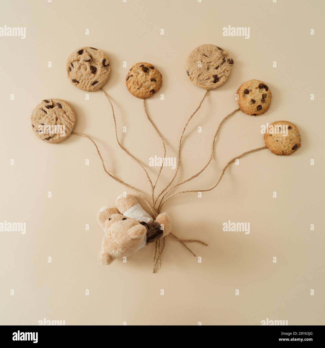 Teddy bear with chocolate cookies balloons on pastel cream background ...