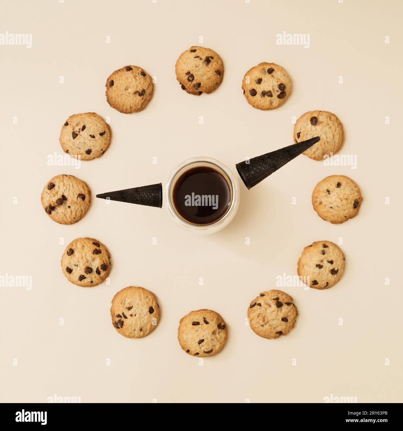 Clock made of cup of coffee, black waffle ice cream cone and chocolate ...