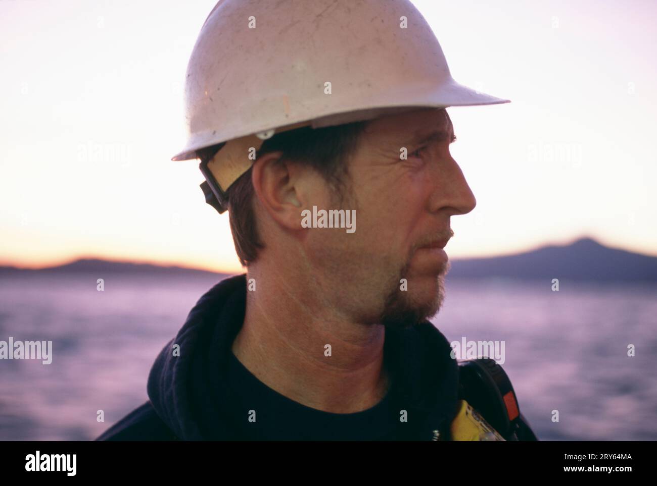 Side view portrait of a deckhand on a tugboat, outside on San Francisco ...