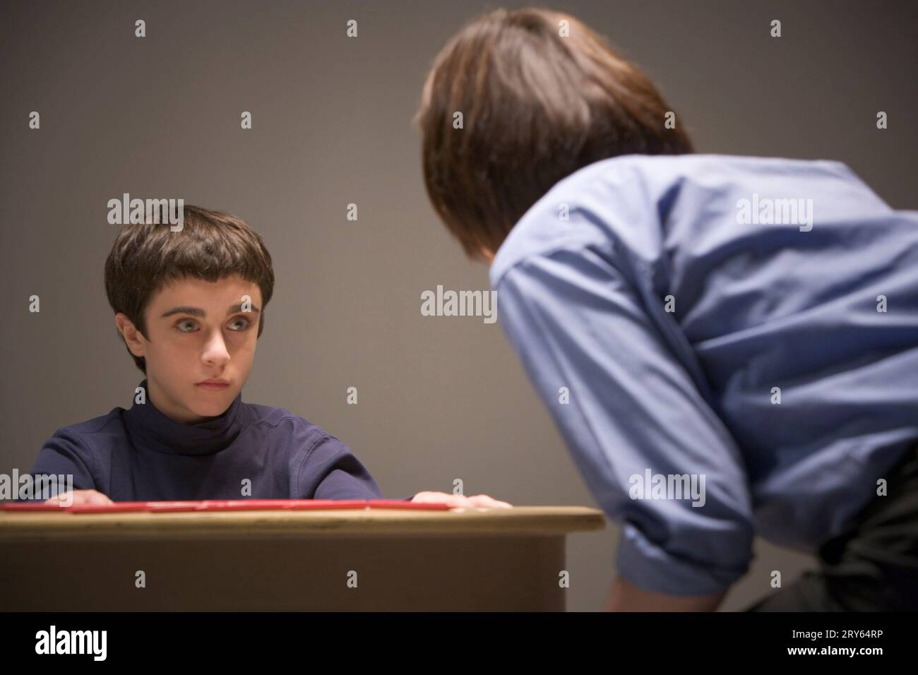 A school boy sitting at a desk staring at a woman Stock Photo - Alamy
