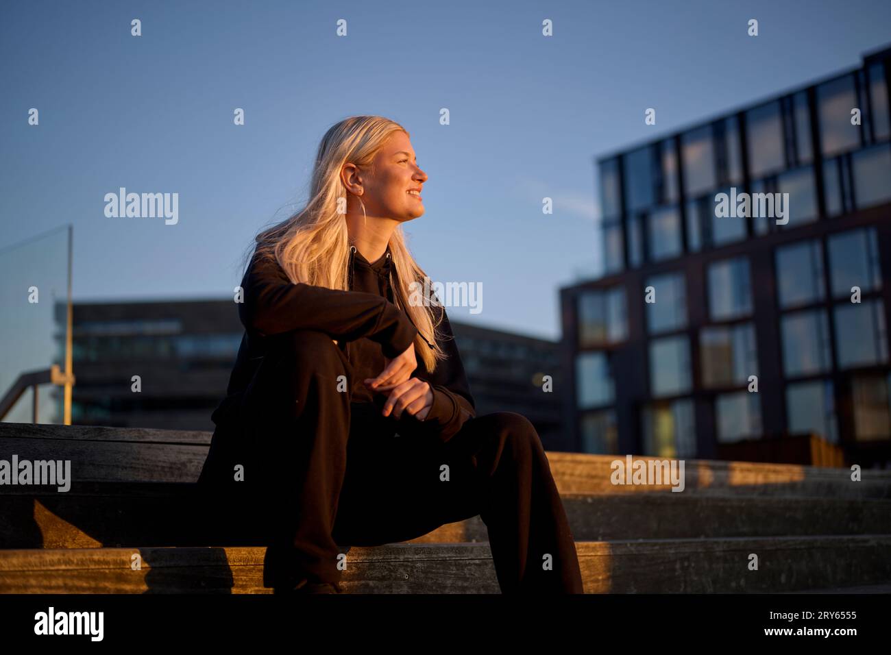 Dreamy woman chilling on street steps in sunlight Stock Photo - Alamy