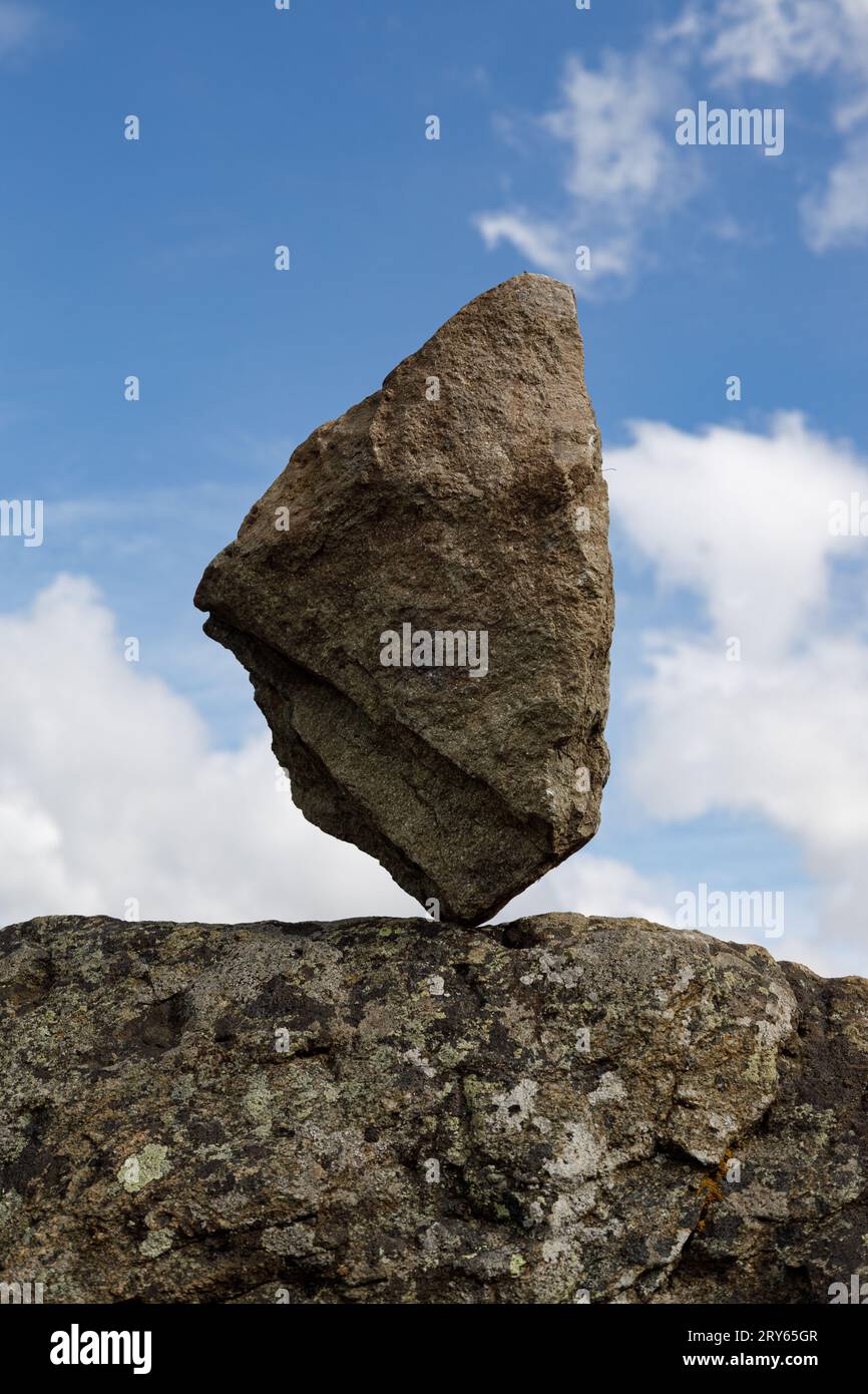 Balancing boulder in front of blue sky with clouds Stock Photo - Alamy