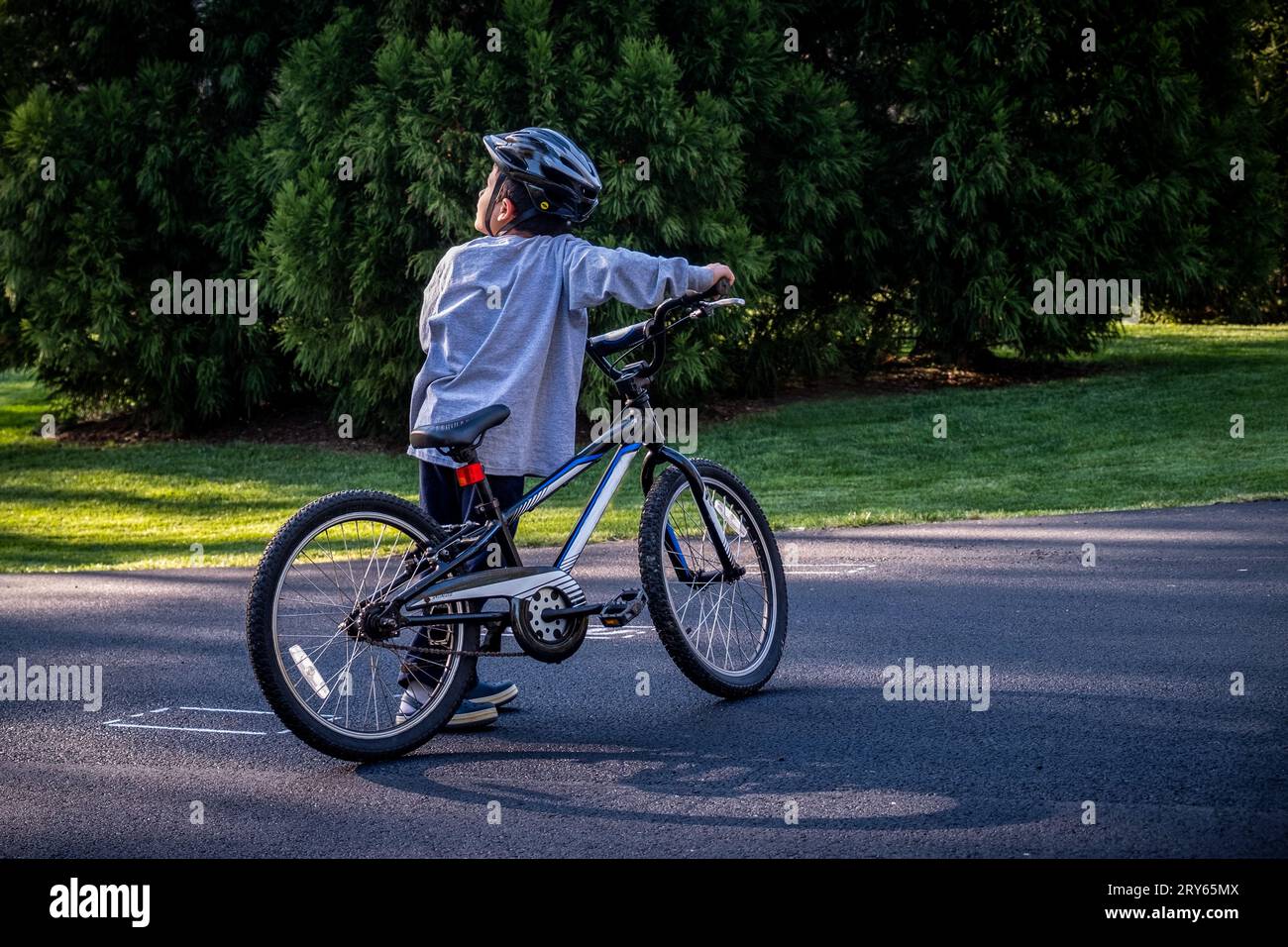 Young boy ridingbike on suburban street Stock Photo - Alamy