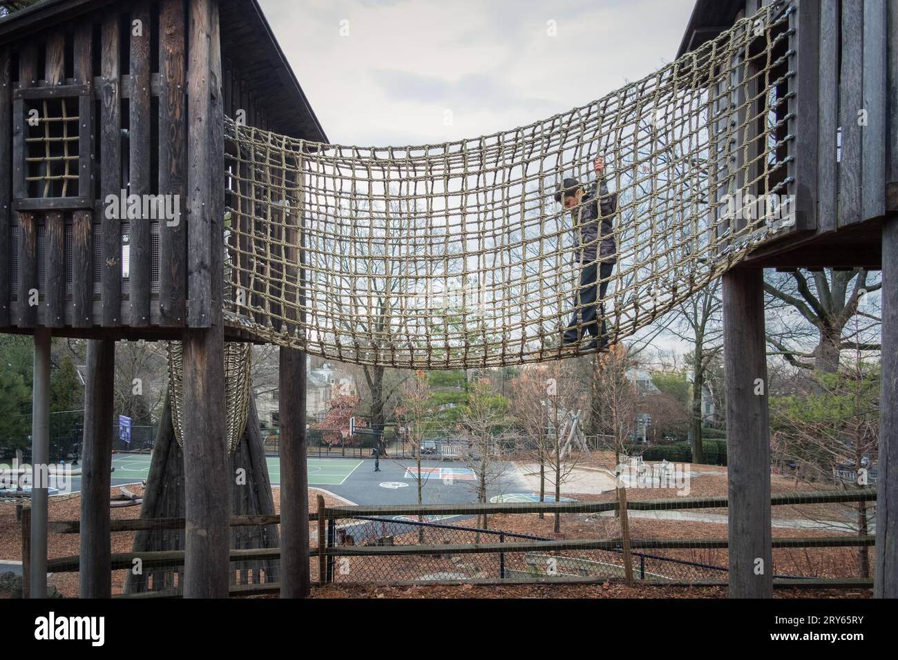 Young boy crossing rope bridge at suburban playground Stock Photo - Alamy