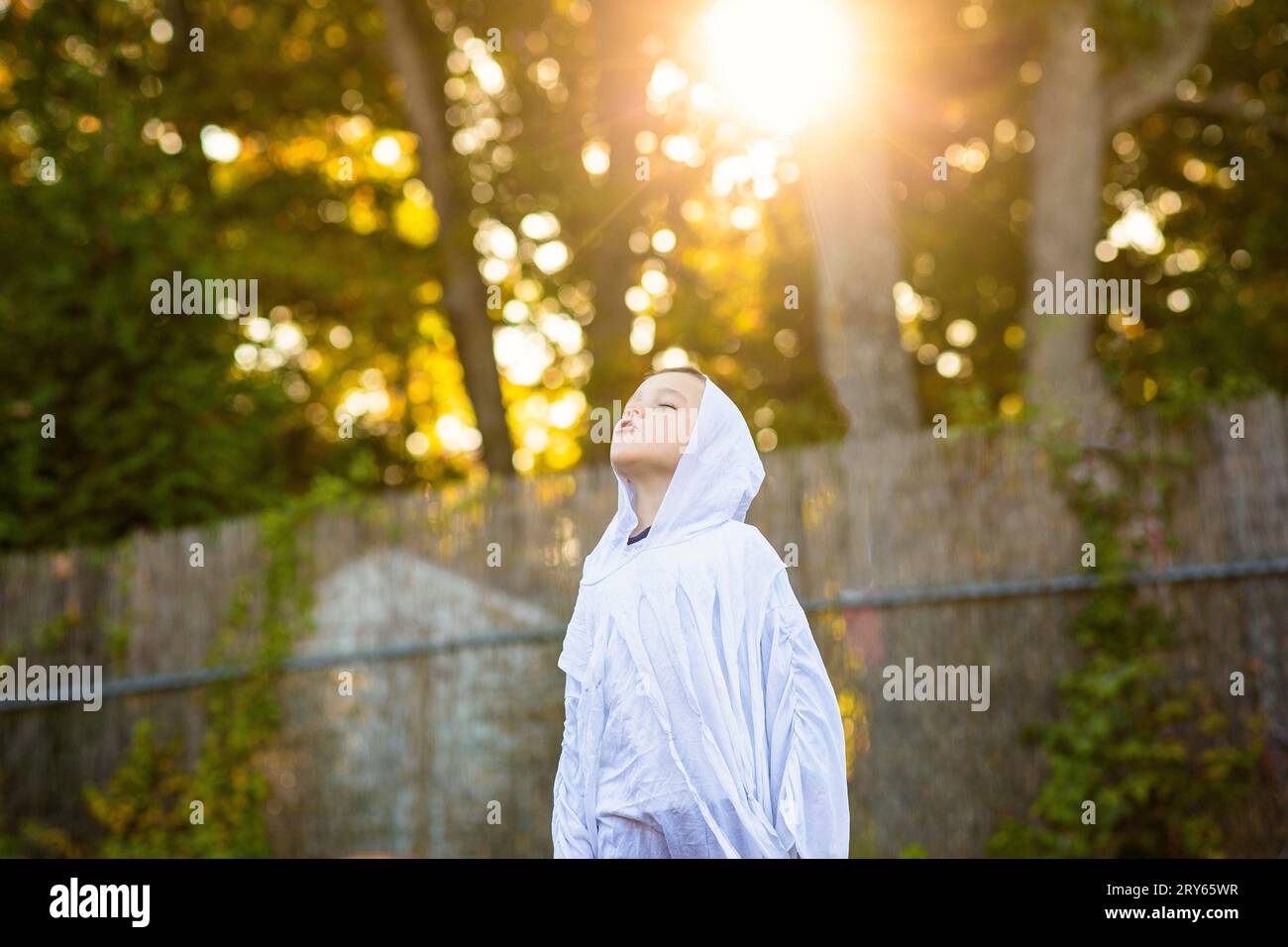 Child howling like a halloween ghost outside during golden hour Stock ...