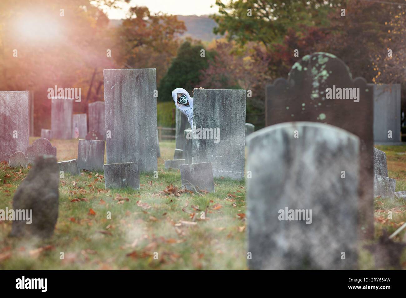 Boy in ghost costume plays in old graveyard Stock Photo - Alamy