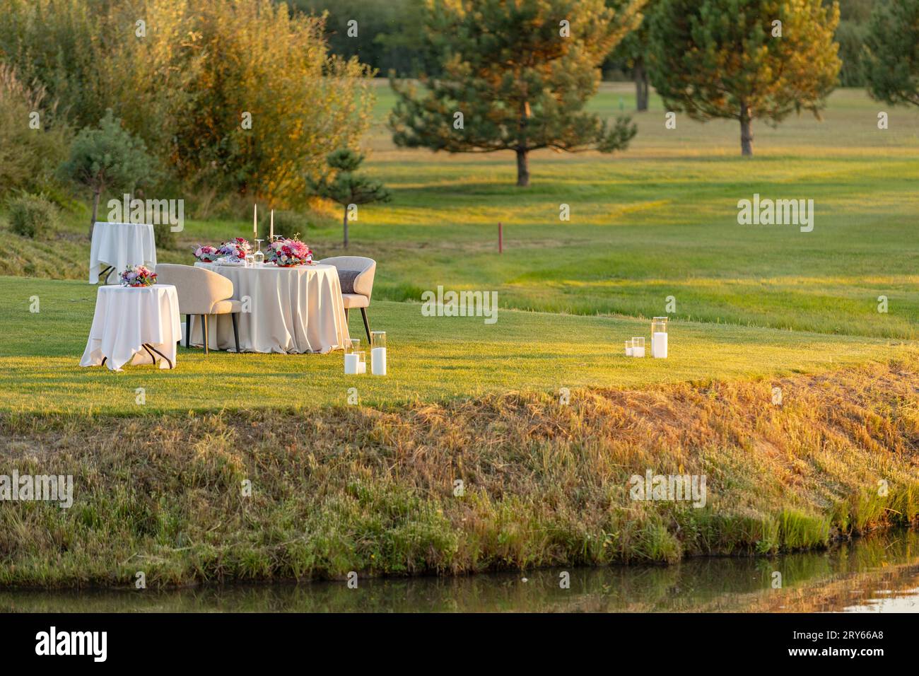 Romantic sunset dinner on the nature. Table honeymoon set with ...