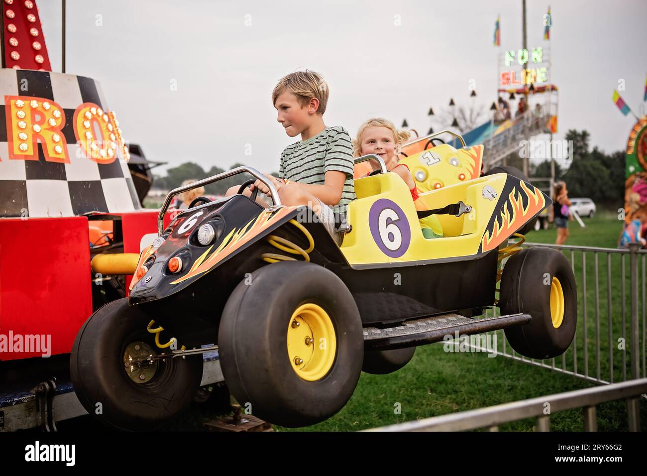 Kids riding carnival ride at the county fair during summer Stock Photo ...