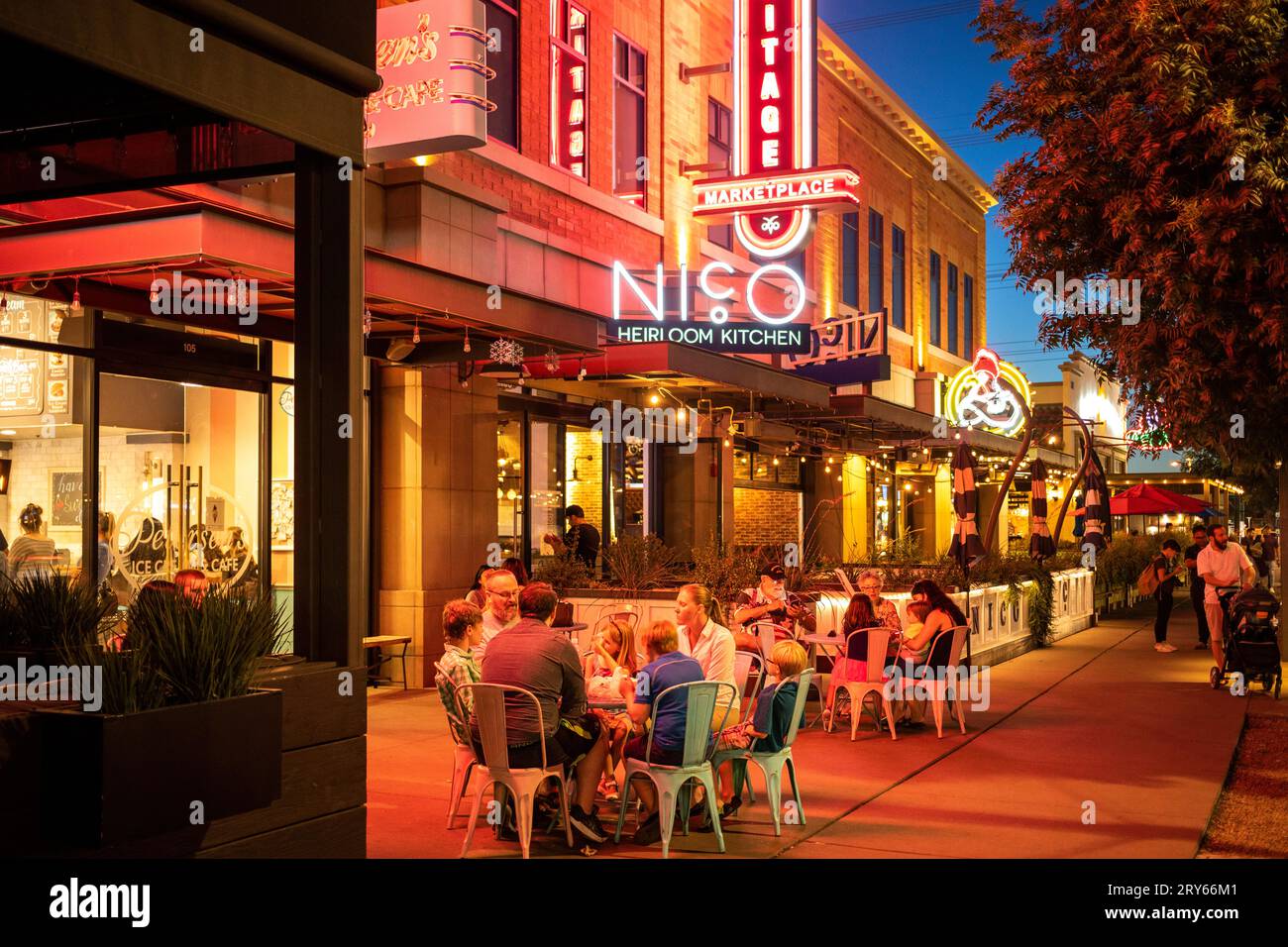 People dining out on patio sidewalk at night under neon lights Stock ...