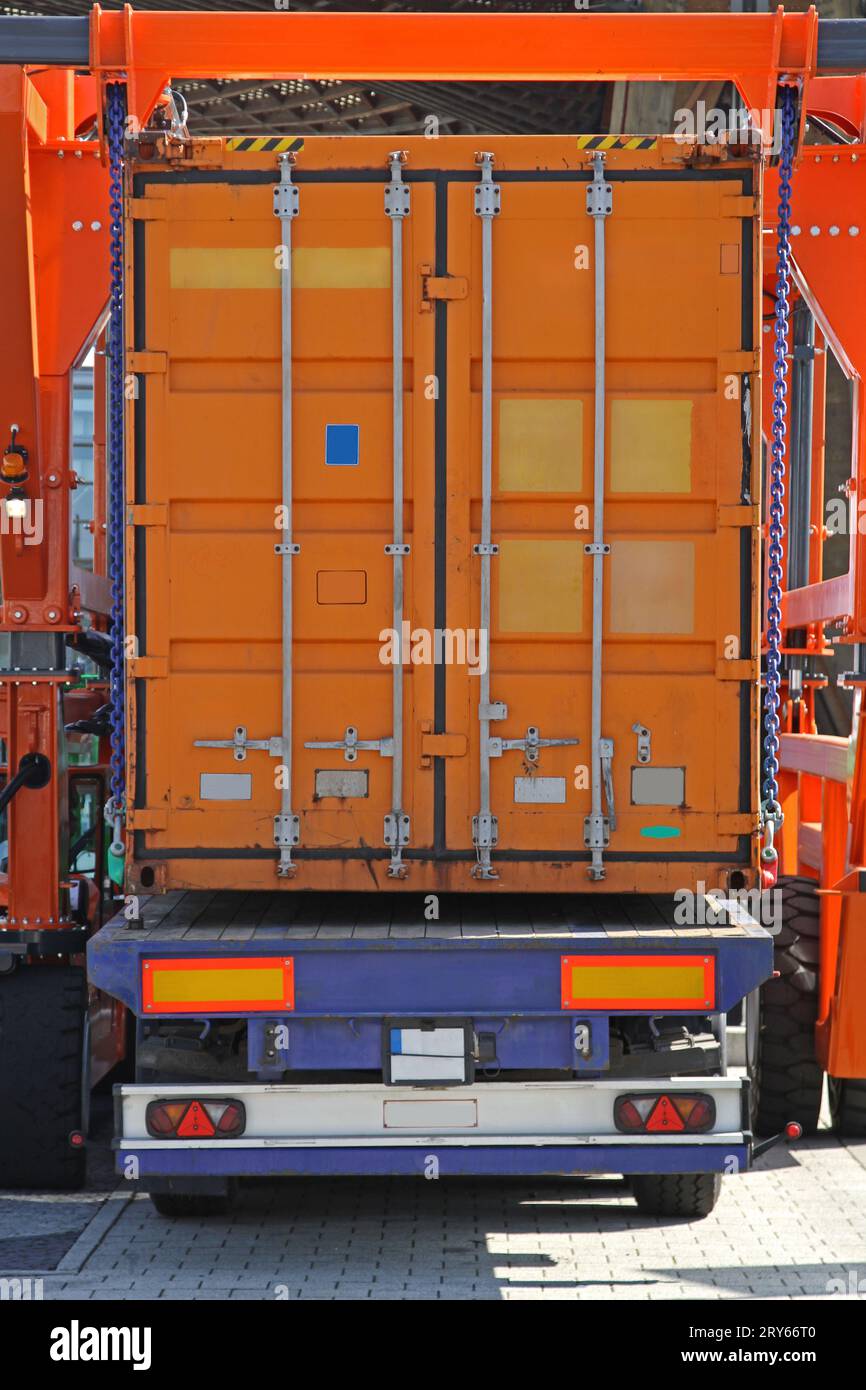 Lifting Orange Shipping Container From Cargo Truck Trailer Stock Photo ...