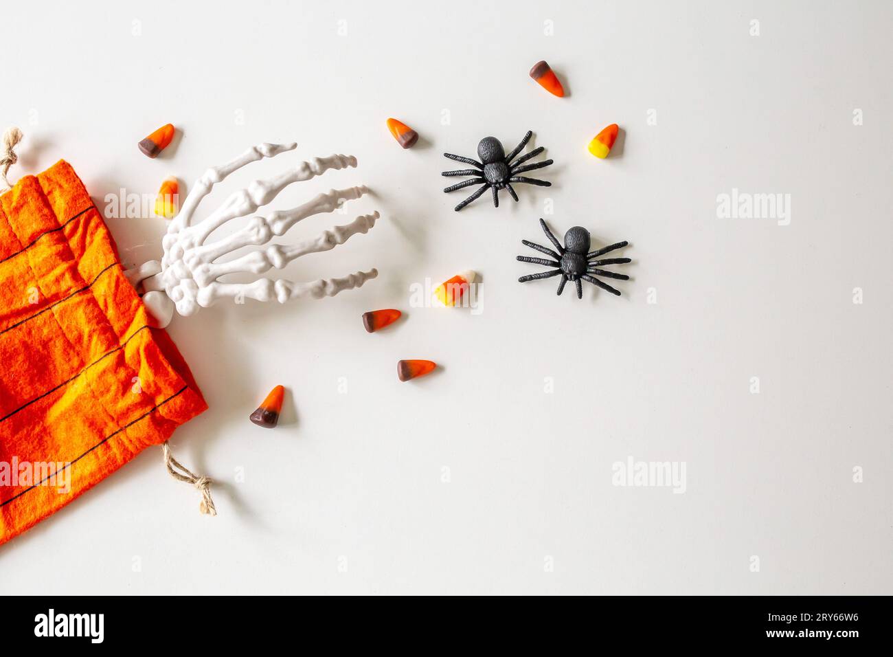 Flat lay with candy corn, spiders and skeleton hand Stock Photo - Alamy