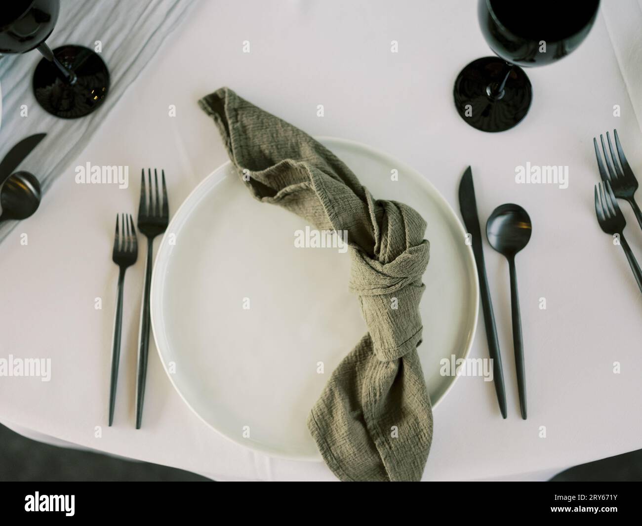Stylish modern table setting in white, black, and sage or olive Stock ...