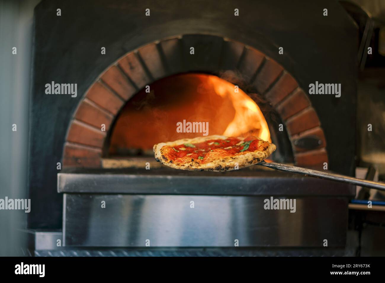Red pizza emerging from wood-fired oven Stock Photo - Alamy