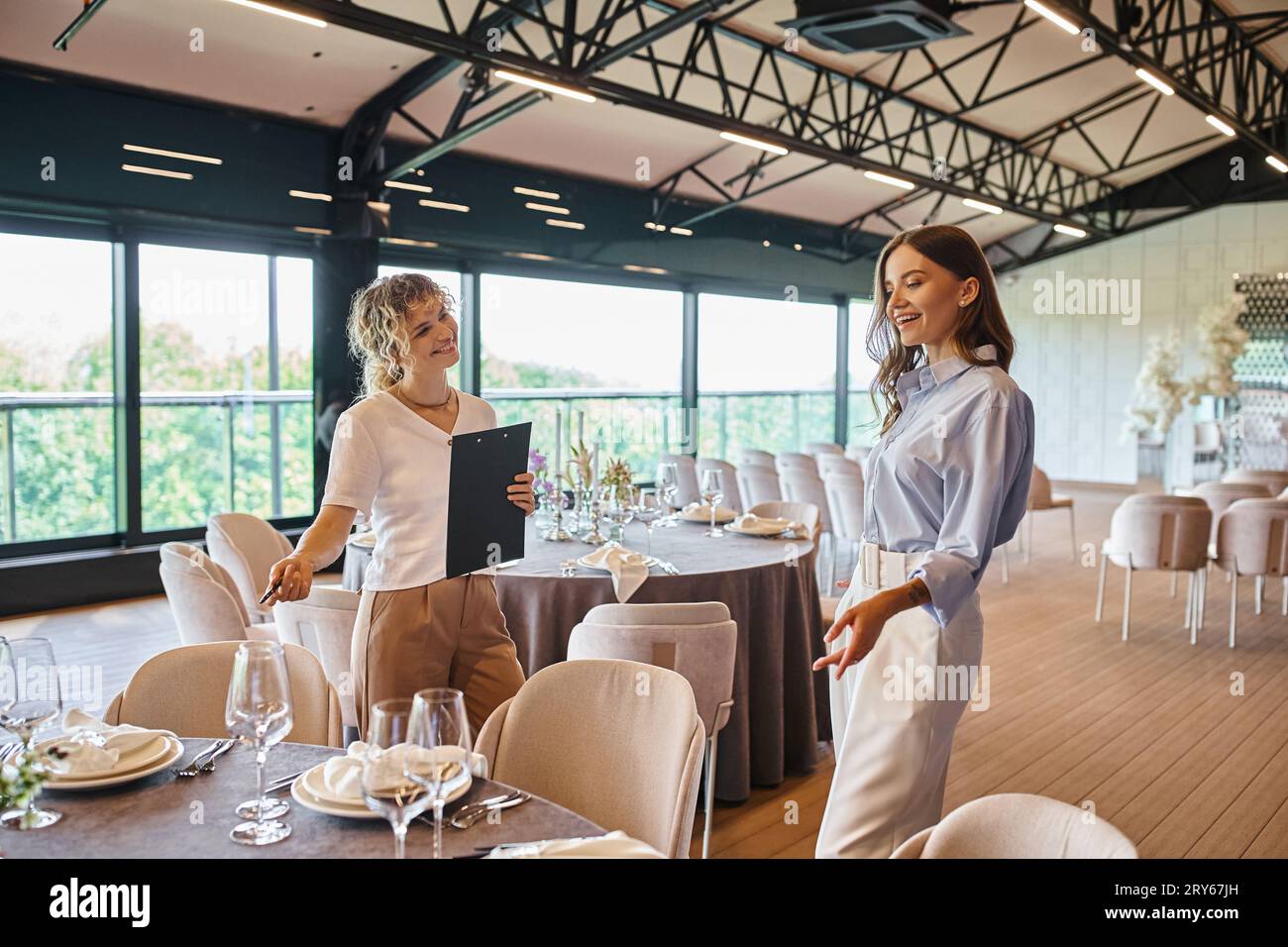event manager with clipboard showing table with banquet setting to ...