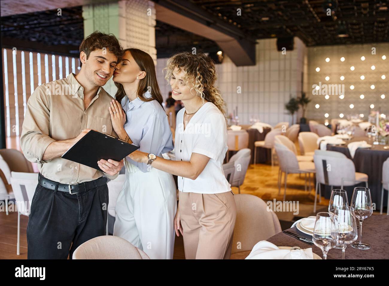 joyful young woman kissing boyfriend signing contract with event ...