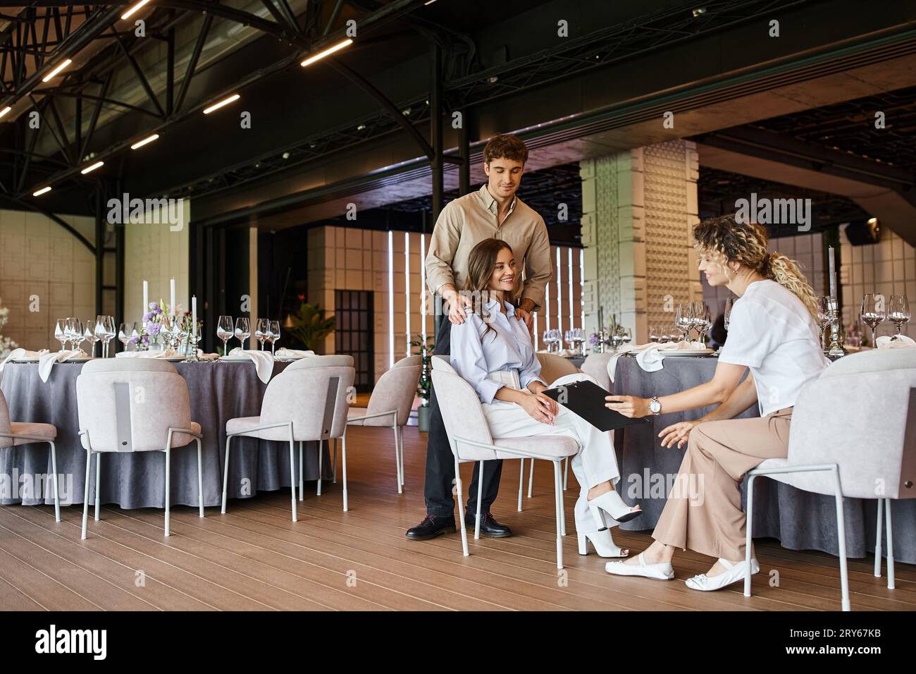 event manager showing clipboard with contract to happy couple in ...